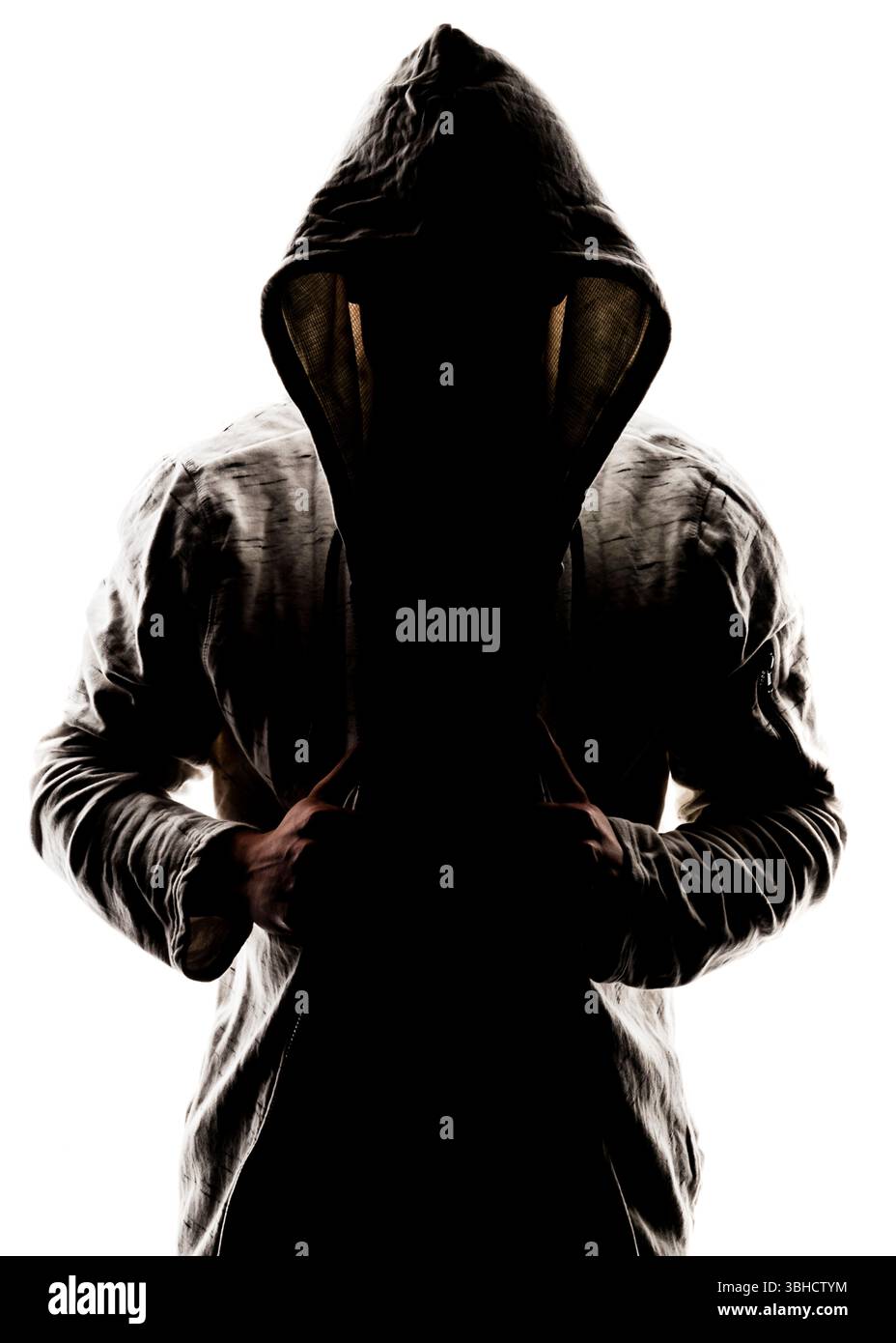 A silhouette of a person wearing a hooded jacket, obscuring their face and identity. The person ...