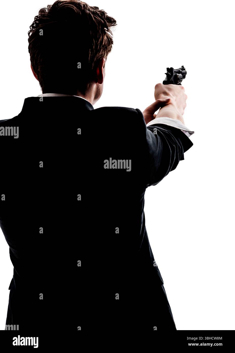 A man in a suit, seen from behind, aims a revolver Stock Photo - Alamy