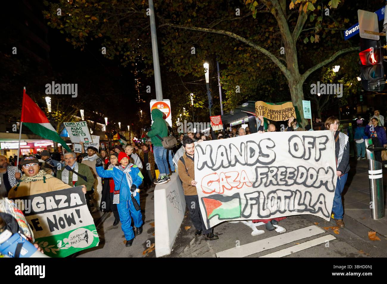 Protestors march through the CBD holding banners during the rally ...