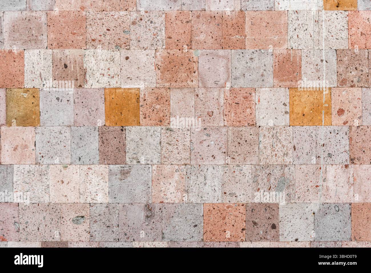 The textured wall is lined with volcanic tuff tiles of various shades ...