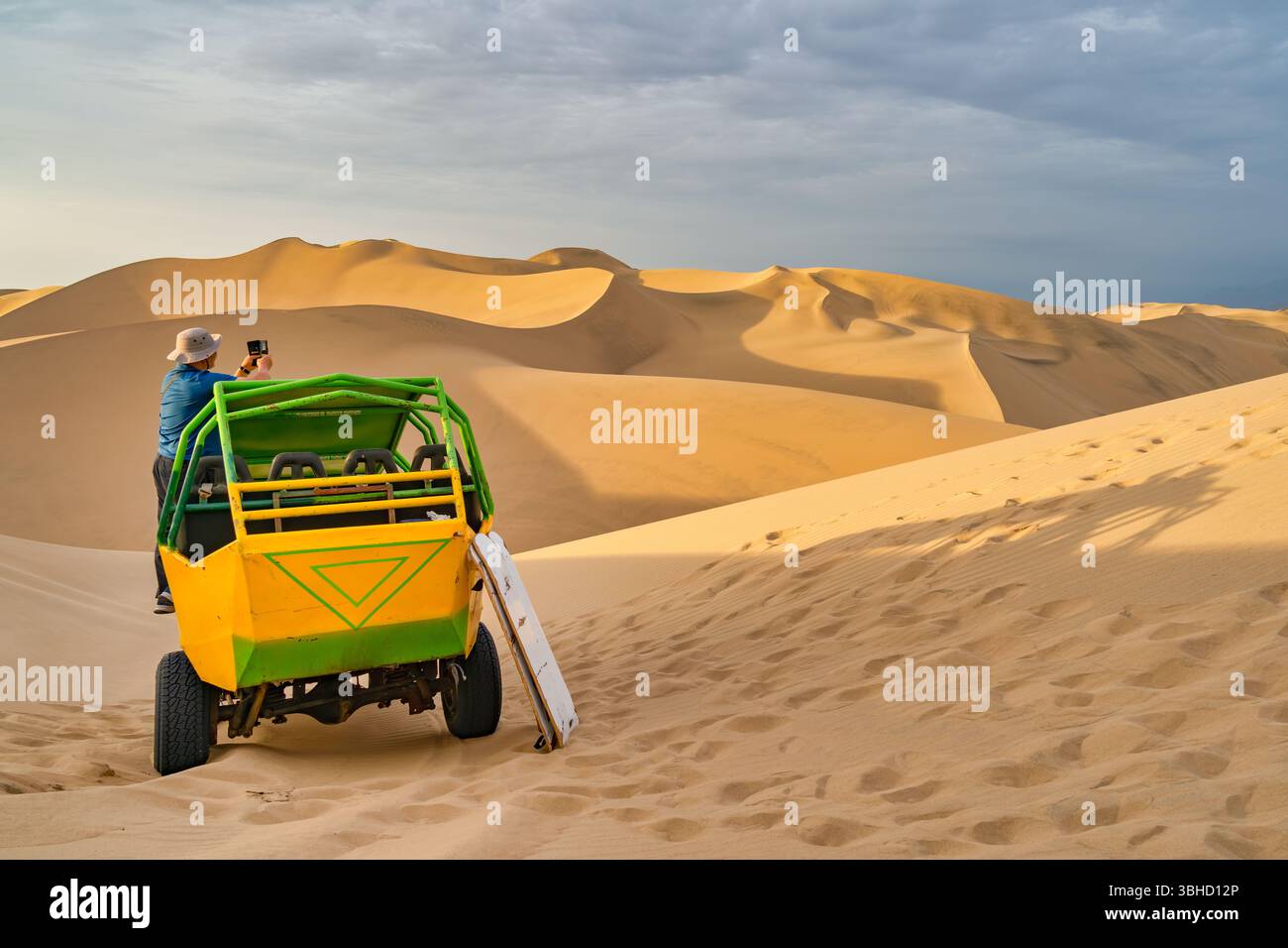 Ica, Peru - March 12, 2025: A man tourist next to a buggy car looking ...