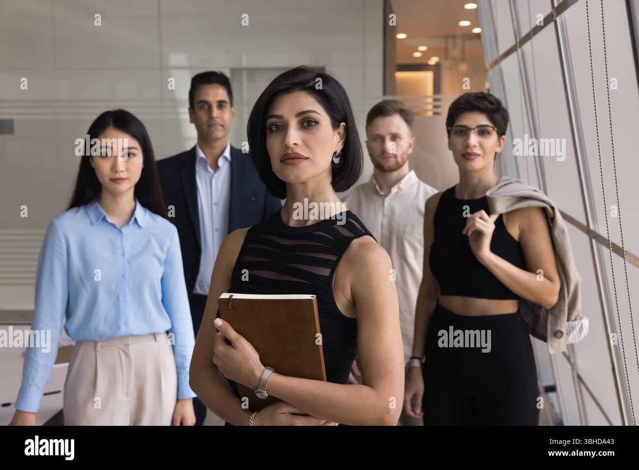 Serious female boss, posing for photo with subordinates Stock Photo - Alamy