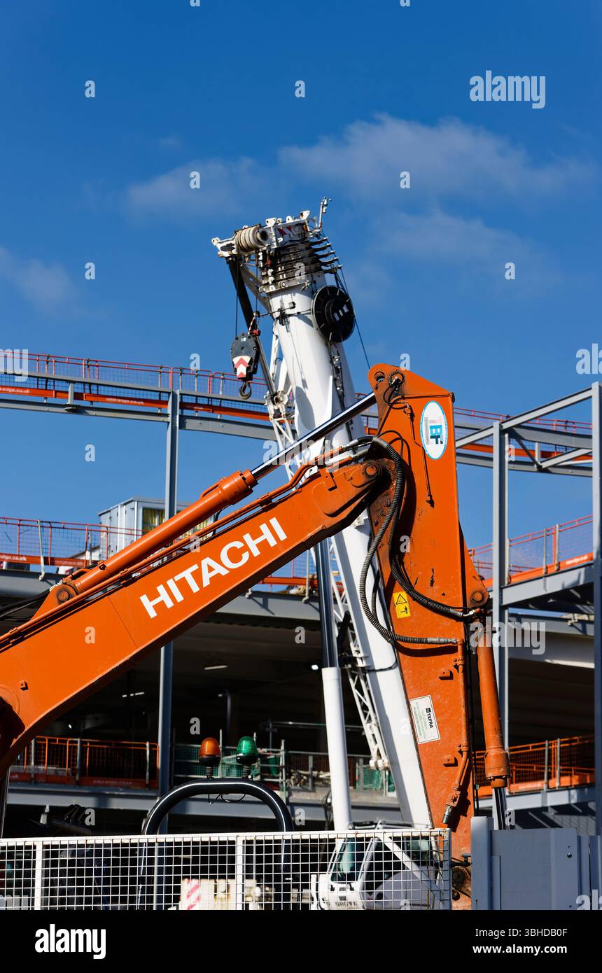 Orange excavator boom and white hydraulic mobile crane boom with steel ...