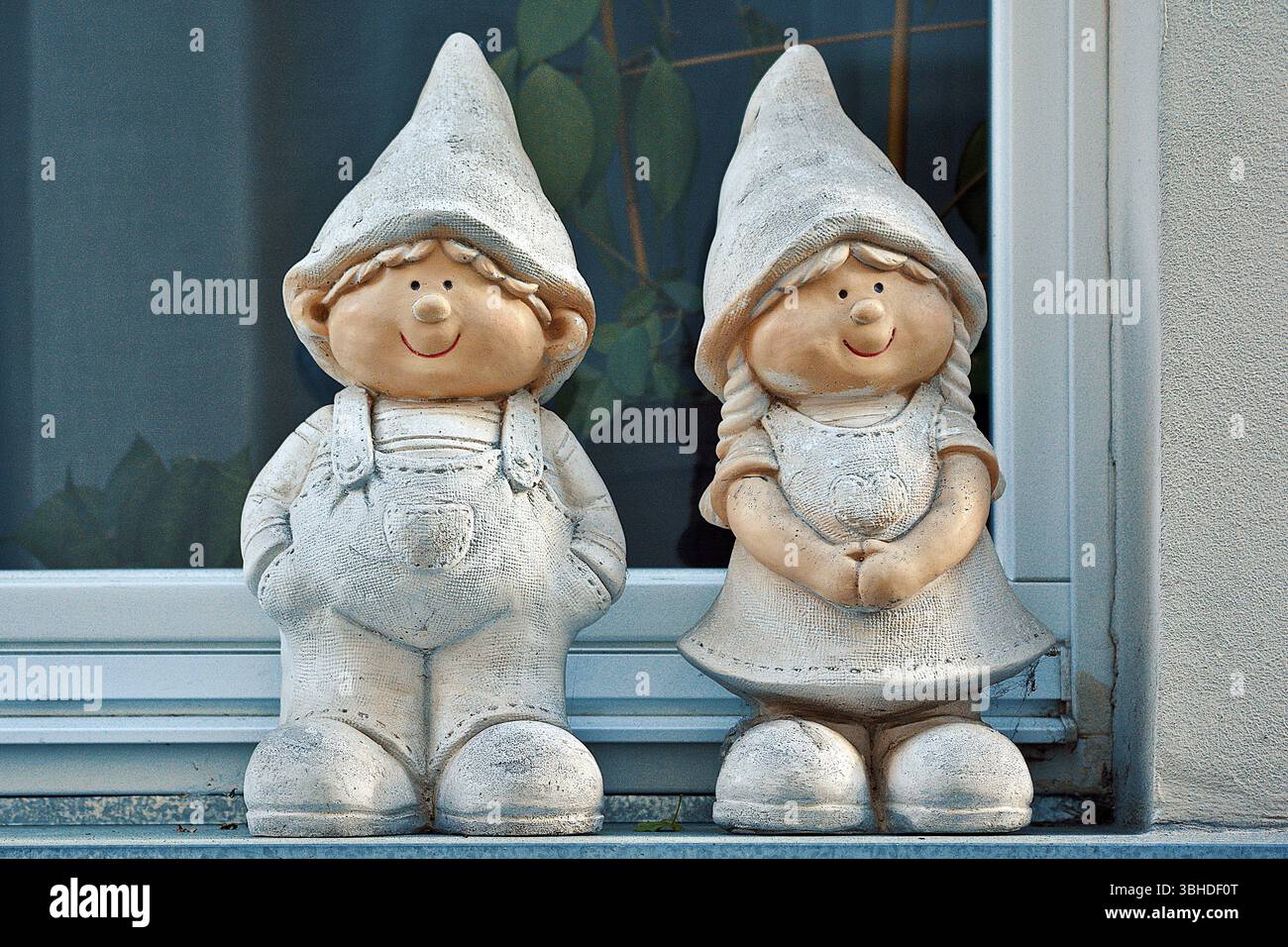 Cute garden gnome figurines of a boy and girl in white clothing ...