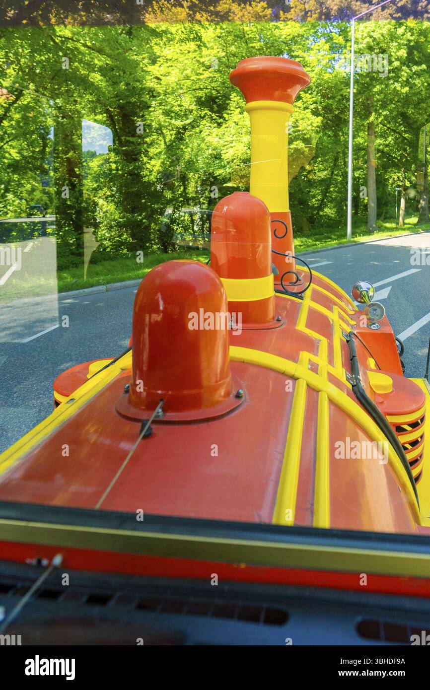 Red and yellow locomotive travelling on a green, sunny road, Calw ...