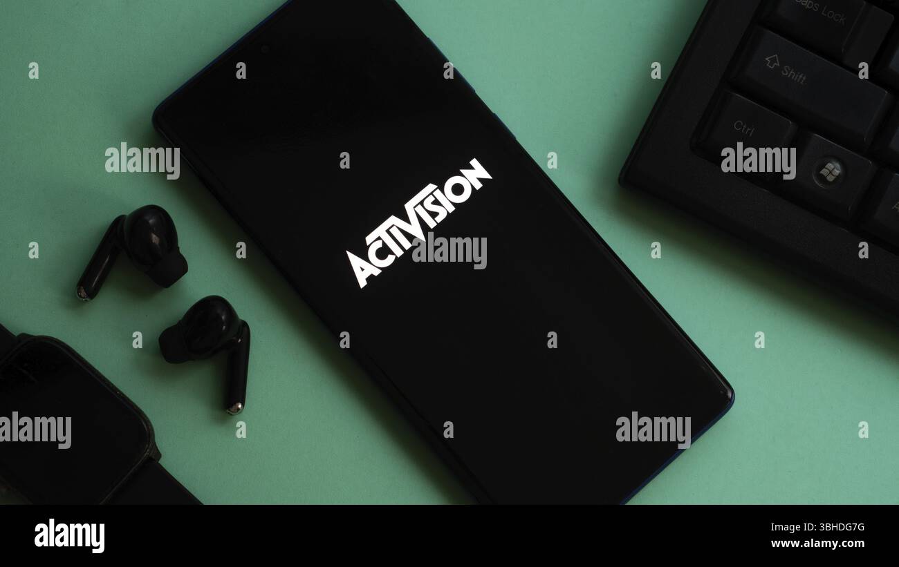 Phone displaying 'Activision' logo alongside a keyboard and earbuds ...