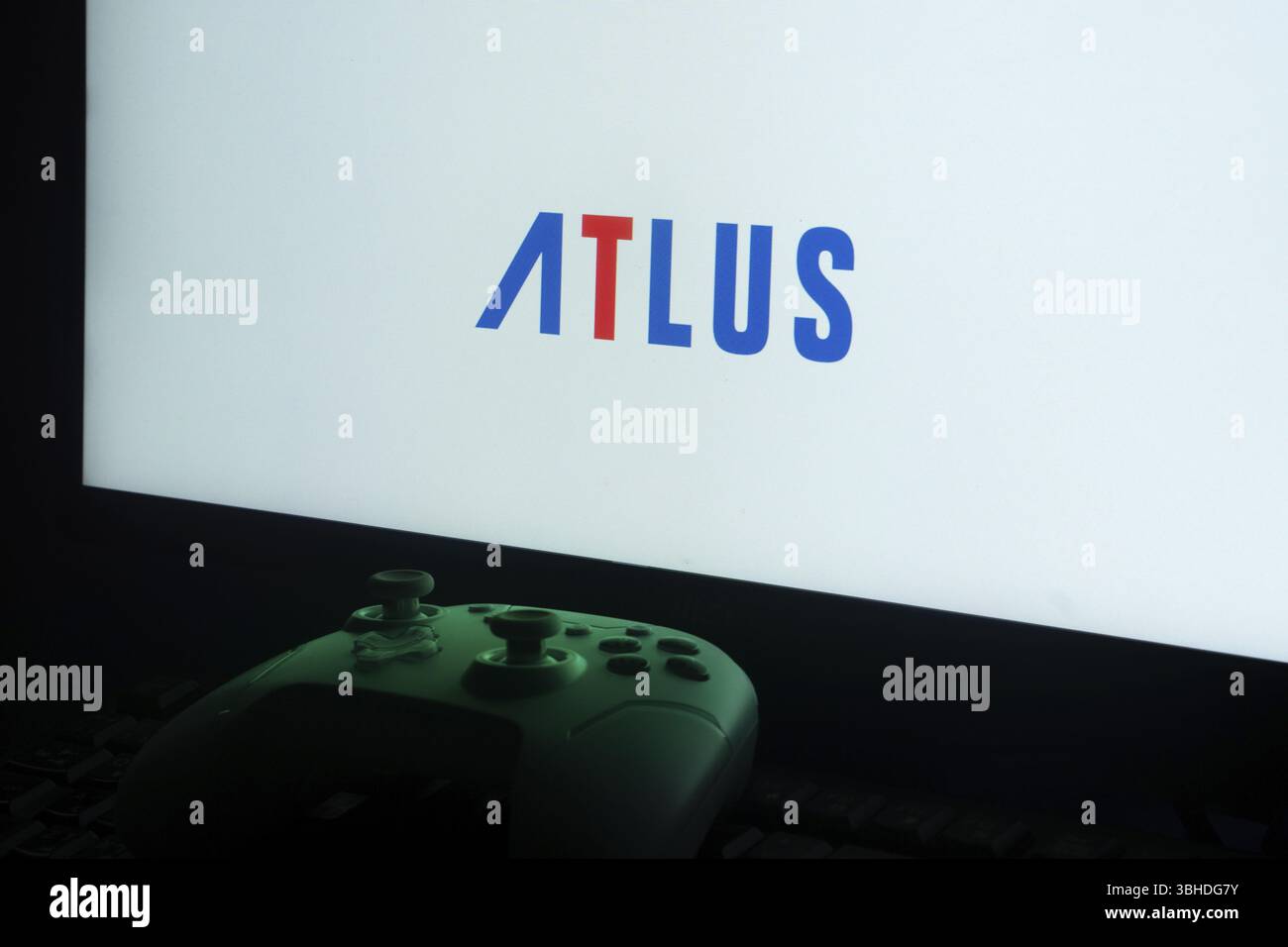 ATLUS logo on a screen with a game controller silhouetted in green ...