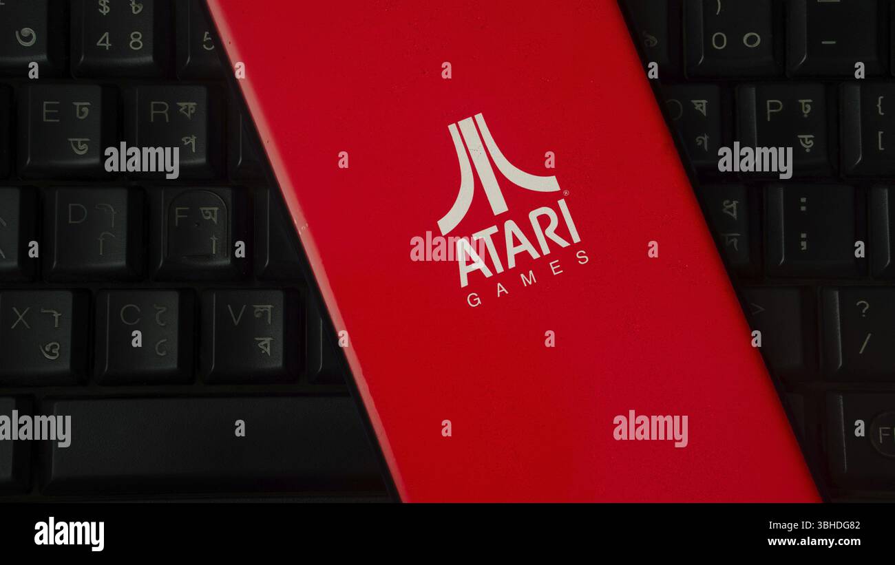 A close-up of a smartphone with an Atari logo on a red surface, resting ...