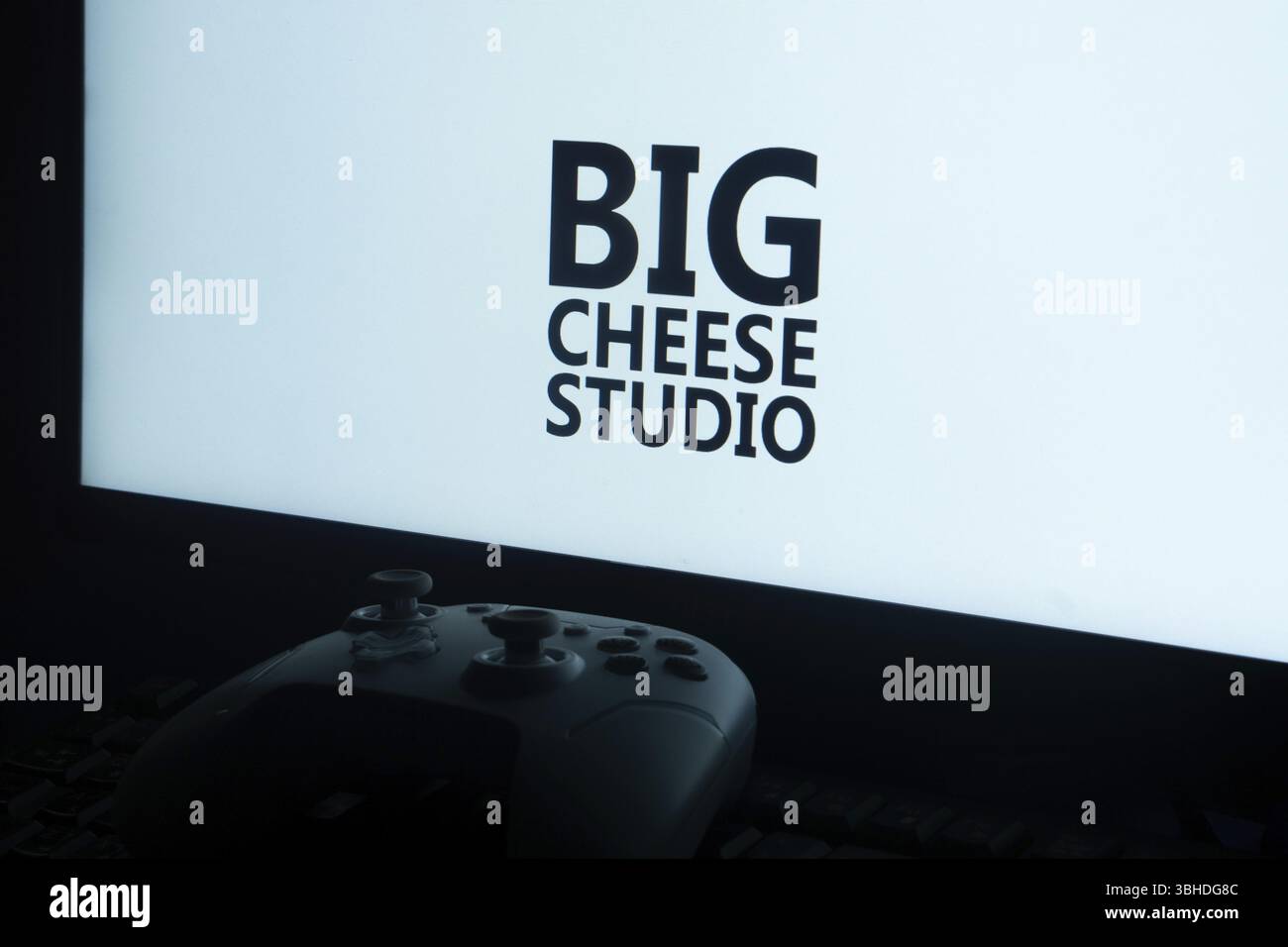 A gaming controller positioned below a screen showing the Big Cheese ...