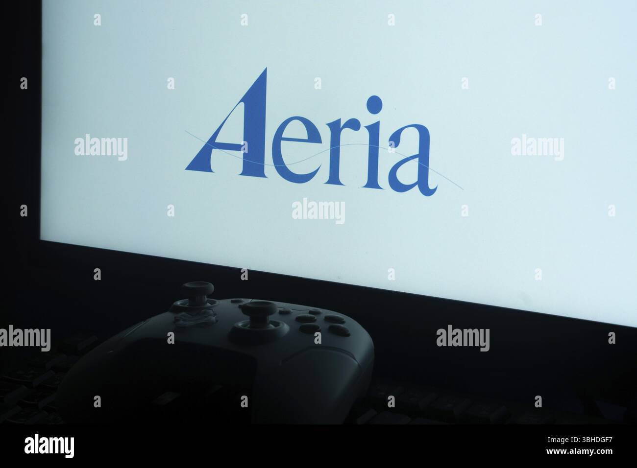 Large screen displaying 'Aeria' logo above a controller Stock Photo - Alamy