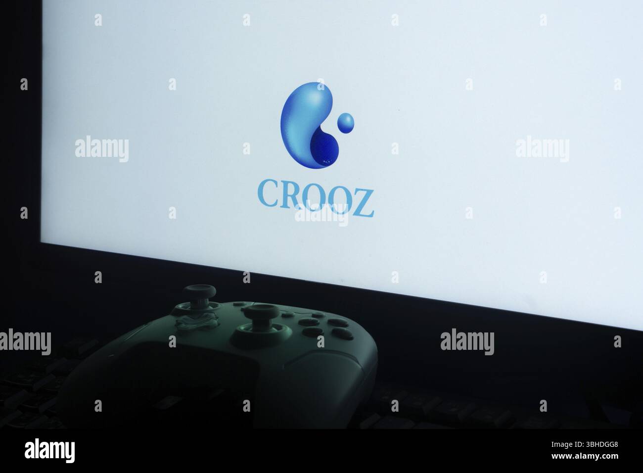 A video game controller in front of a screen displaying Crooz logo in a ...