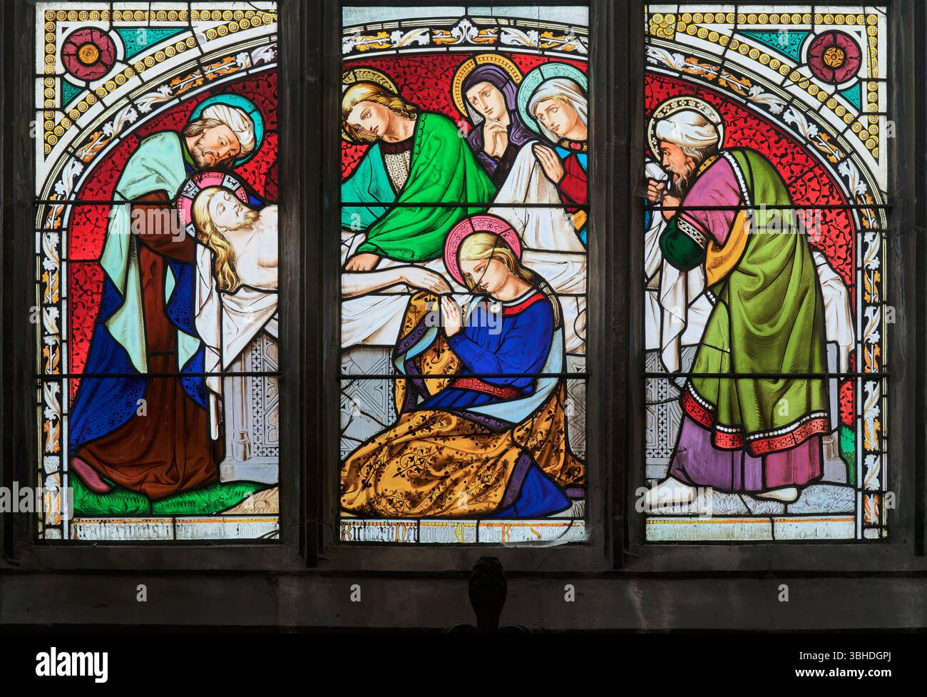 Stained-glass window, of the burial of Jesus Christ, in the christian ...