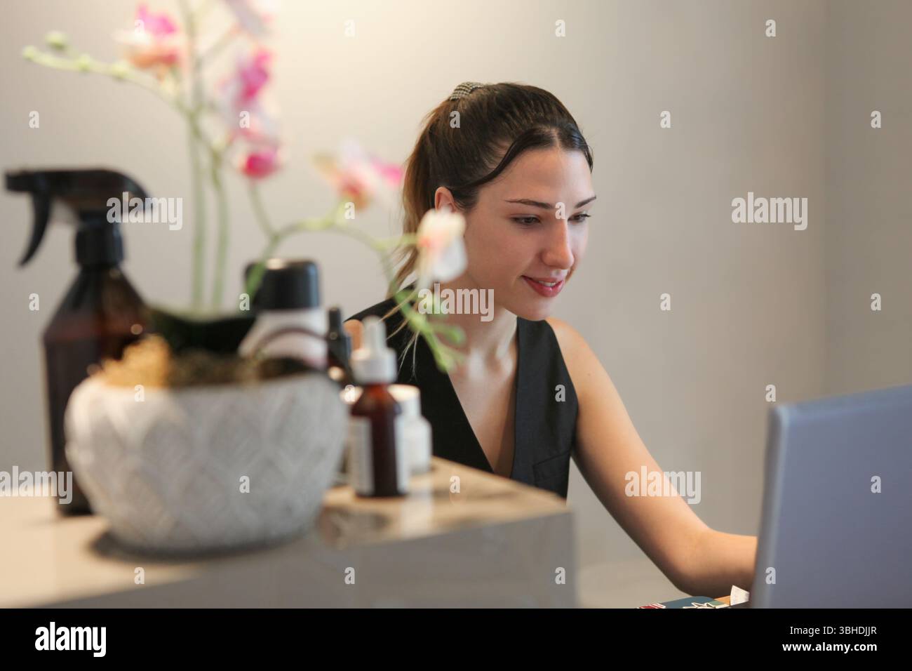 Young woman at a modern reception desk, working on a computer Stock ...