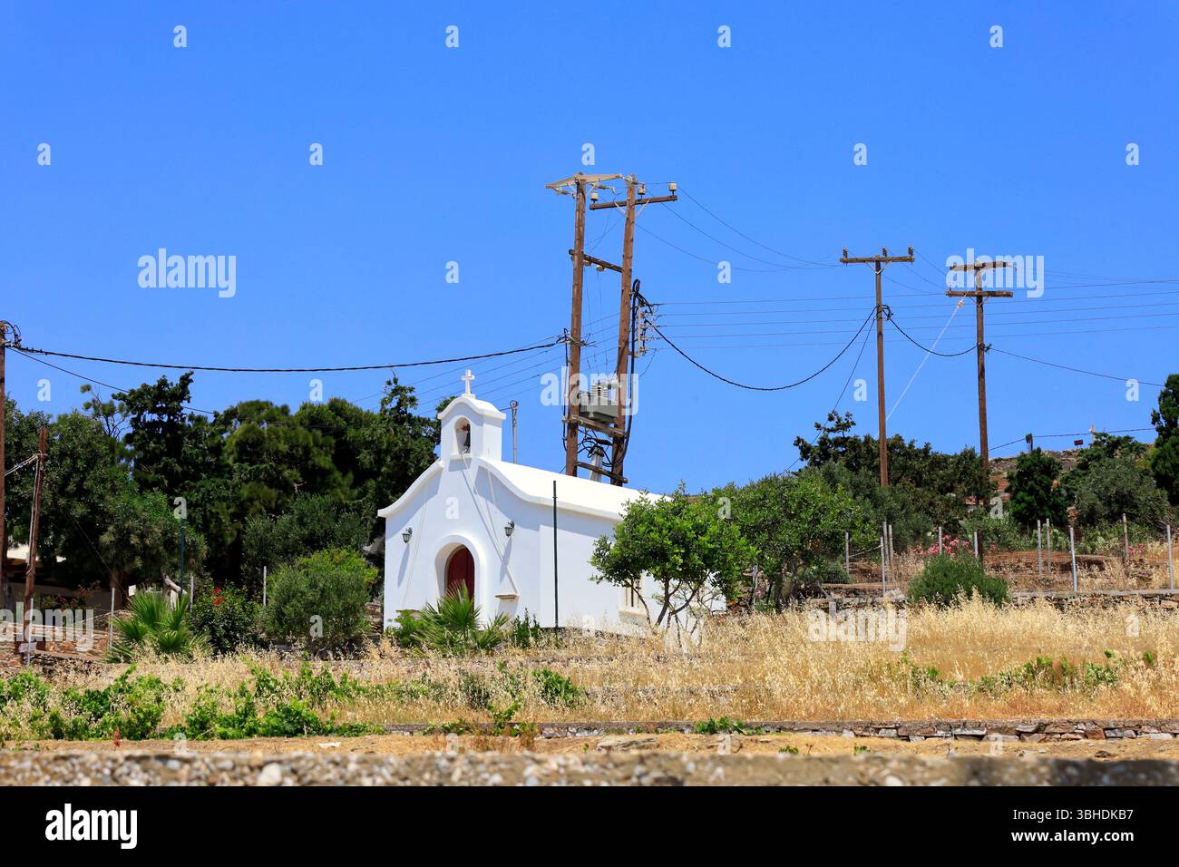 Small whitewashed church and rickety looking electricity poles, Tinos ...