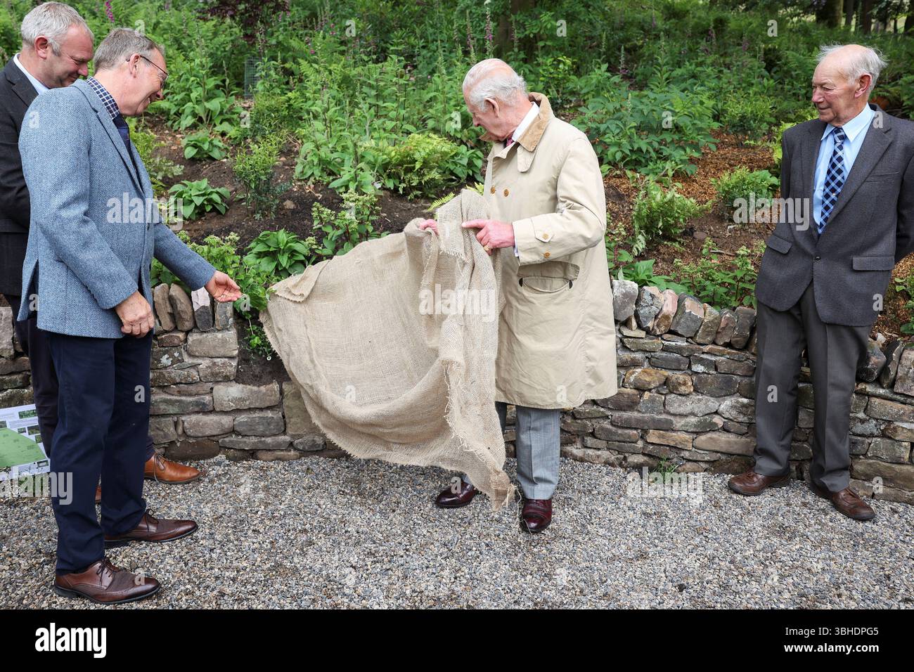 King Charles III unveils a plaque commemorating his visit as he opens ...