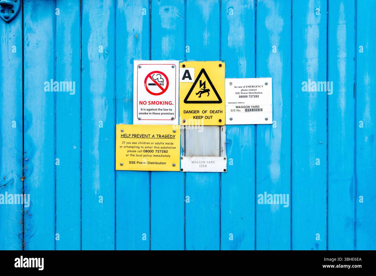 Group of warning signs on a blue painted wooden door Stock Photo - Alamy