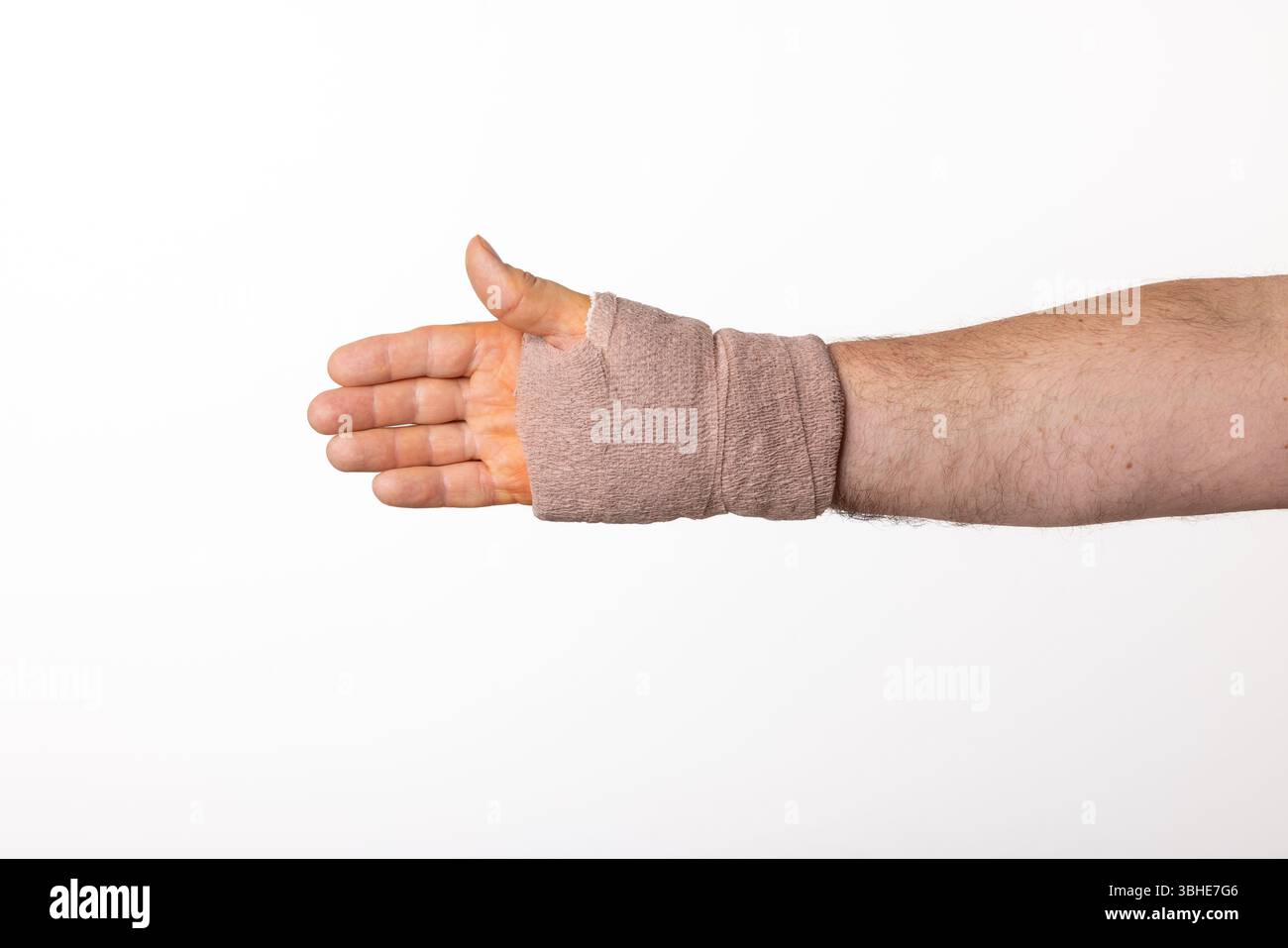 A man's hand and wrist wrapped in a cloth bandage after carpal tunnel ...