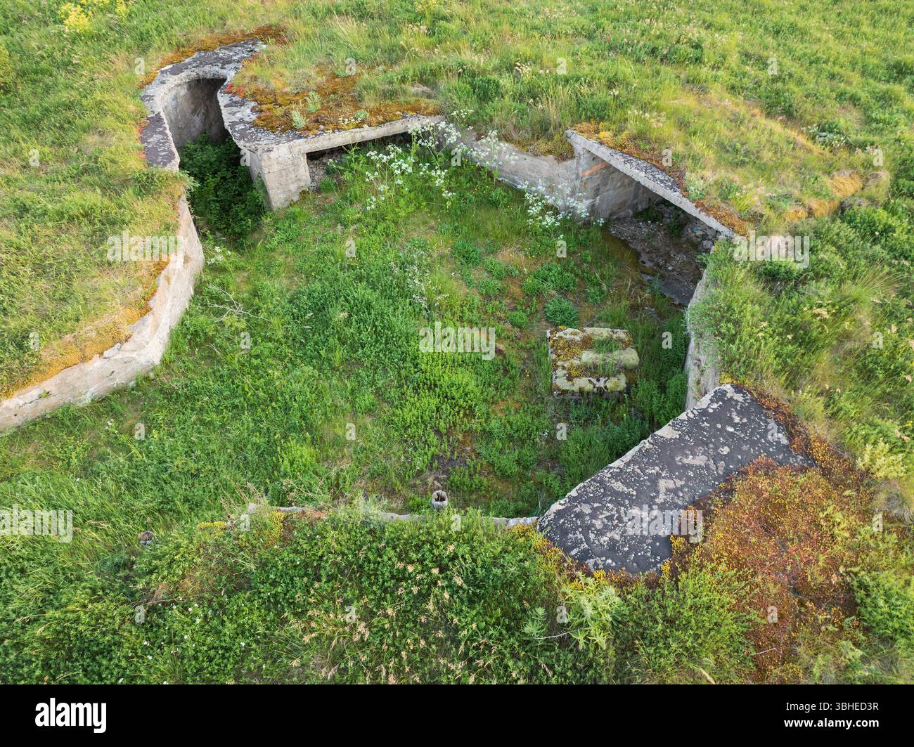 Aerial view of an abandoned Soviet military bunker overgrown with green ...