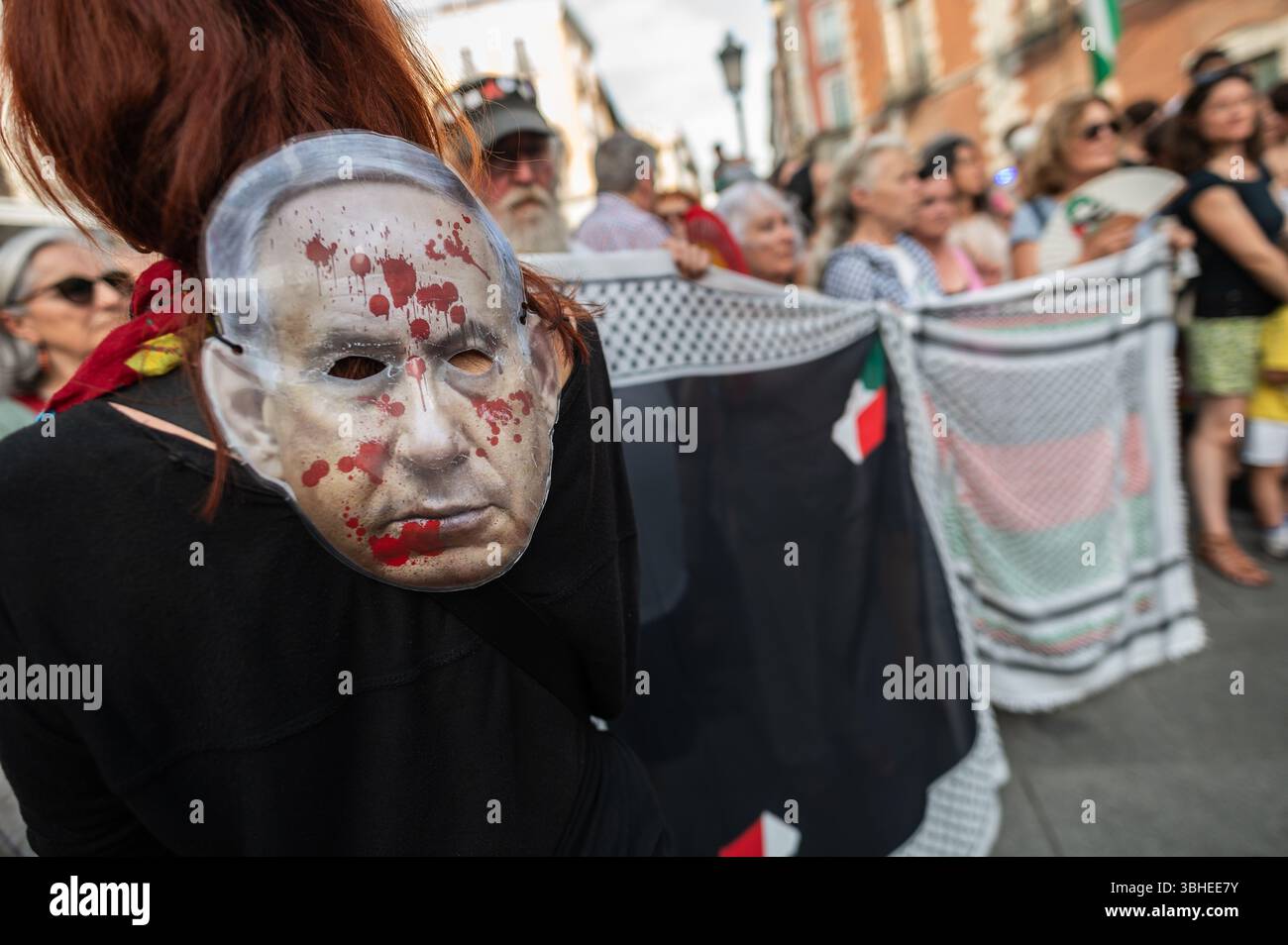 A woman carries a mask with the face of the Prime Minister of Israel ...