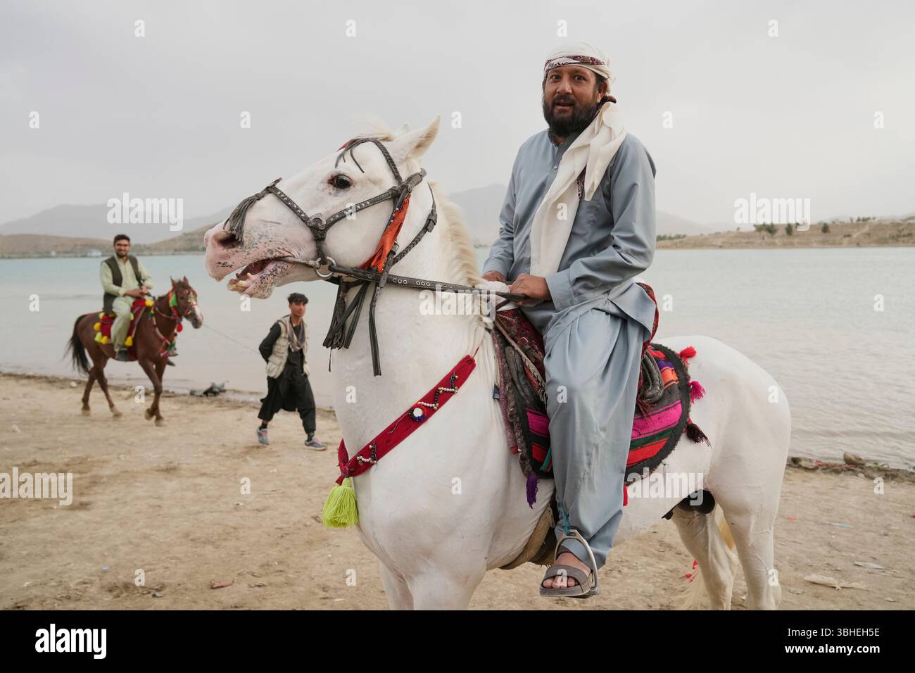A man rides a horse by the lake Qargha in Kabul, Afghanistan, Monday ...