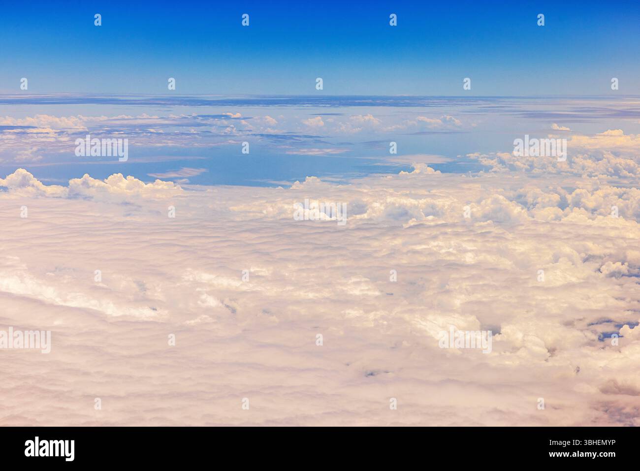 Aerial view of soft layered clouds stretching across sky with distant ...