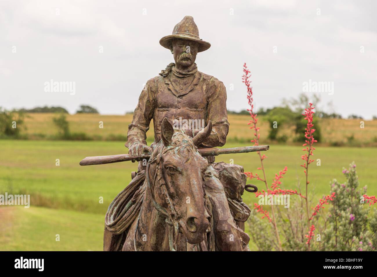 Statue of a cowboy riding his horse and carrying a gun across his ...