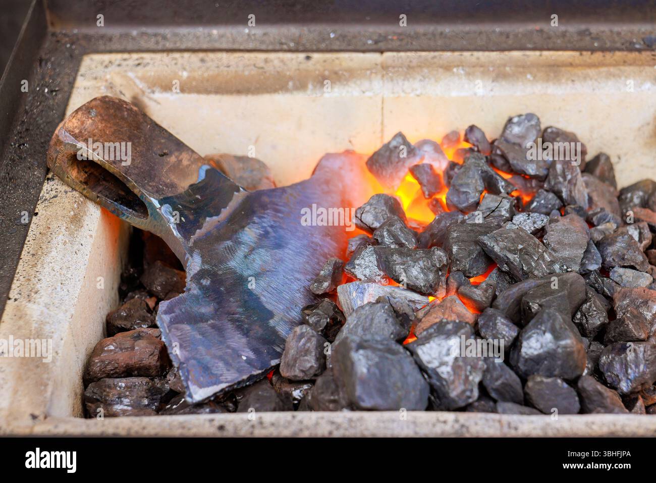 Blacksmith heats large metal tool hi-res stock photography and images ...