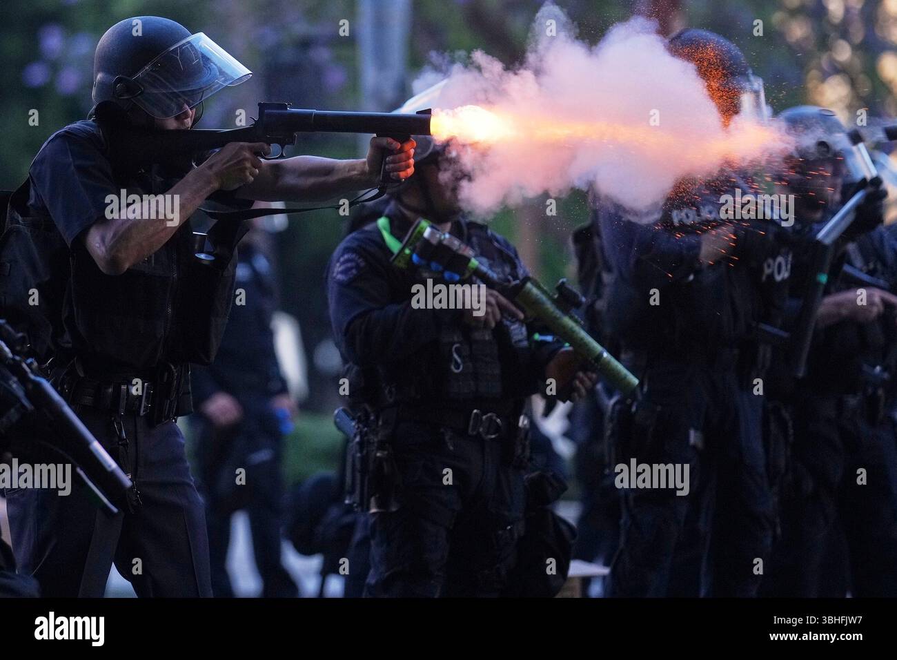 FILE - A police officer fires a soft round near the Metropolitan ...