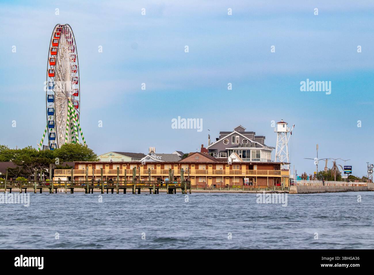 A scenic view of the Ocean City boardwalk with a large Ferris wheel ...