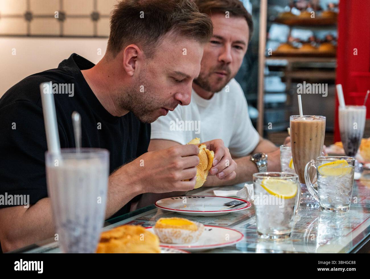 Judd Trump (left) savors a pineapple bun. Hong Kong,China.9th June 2025 ...