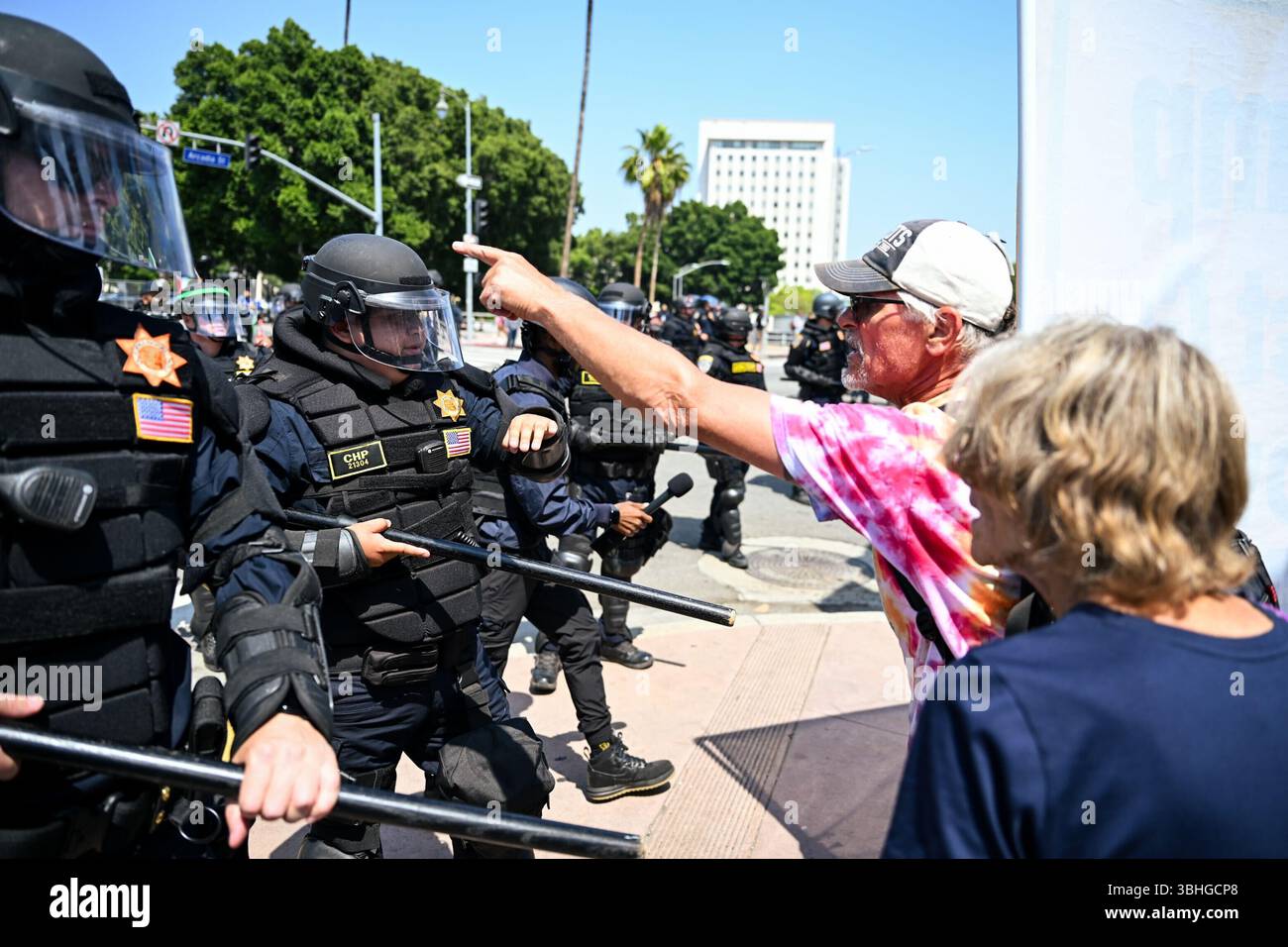 Los Angeles, USA. 09th June, 2025. A man stands opposite officials ...