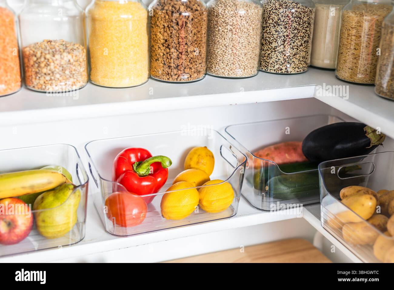 small organized pantry with matching clear jars filled with grains ...