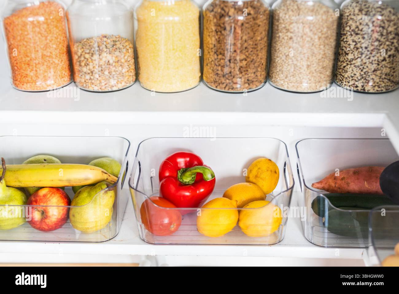small organized pantry with matching clear jars filled with grains ...