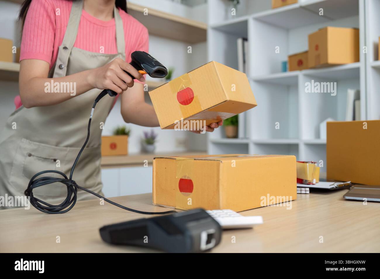 Small Business Efficiency. Female entrepreneur scanning packages for inventory management Stock ...