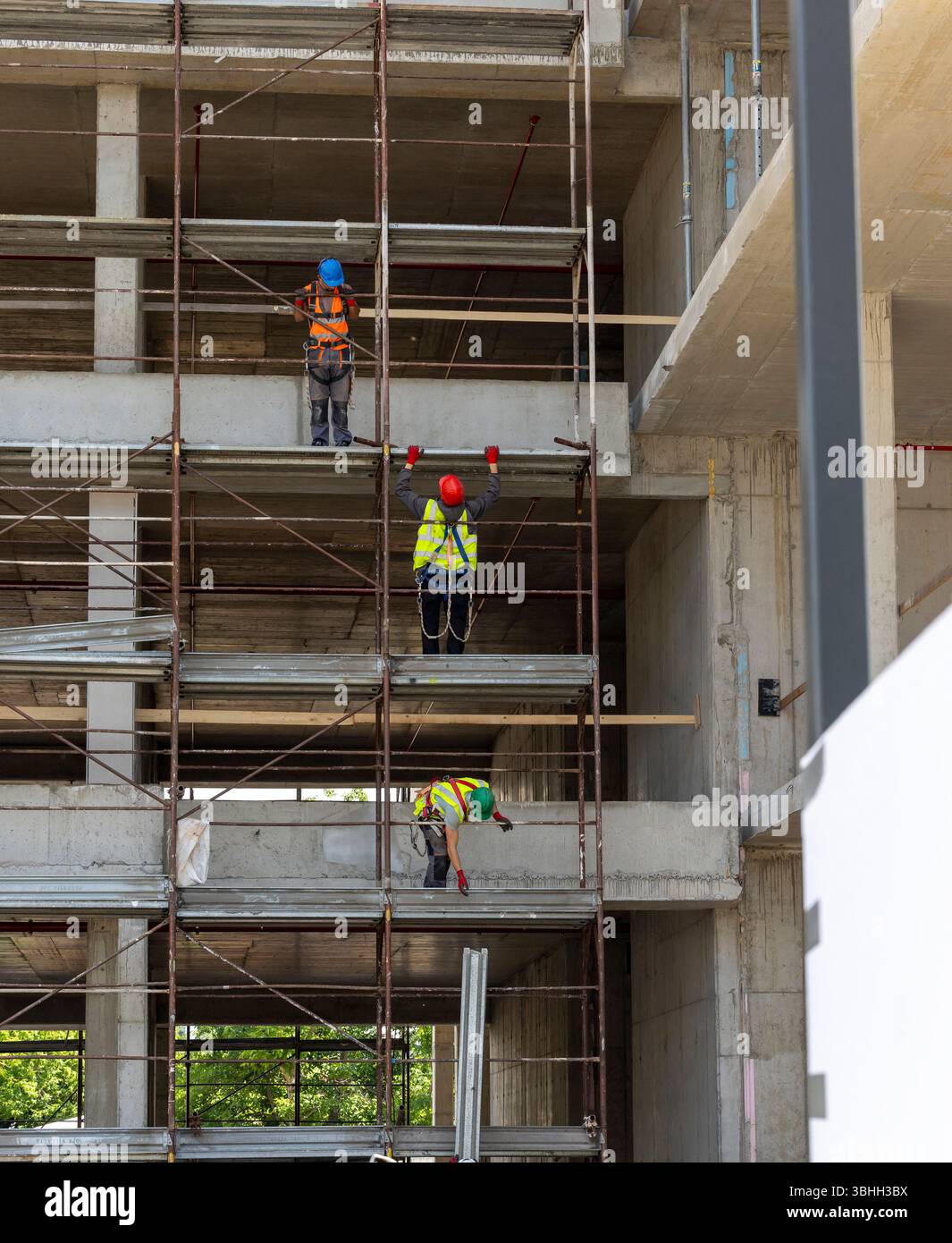 Construction workers assembling scaffolding on a construction site in ...