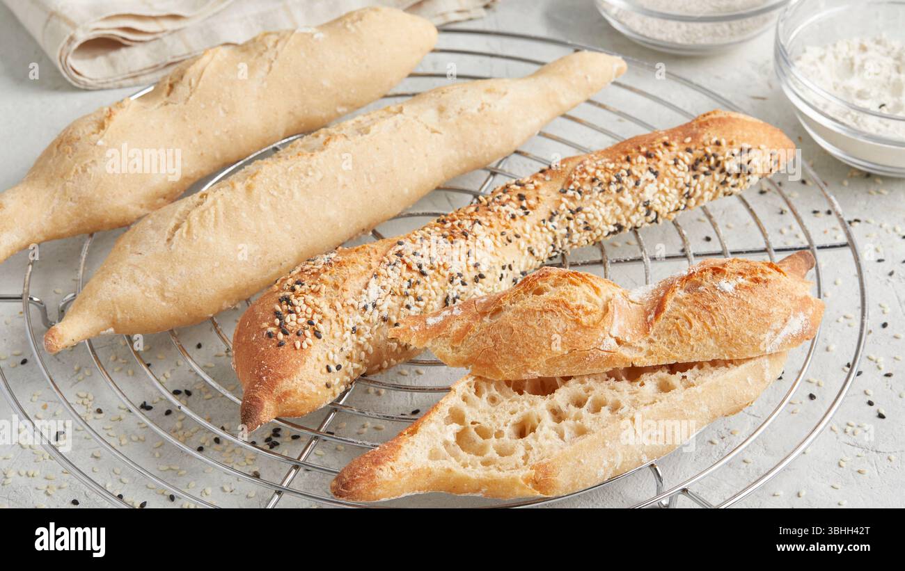 Baguette on cooling rack and wood surface – a rustic artisan loaf with ...