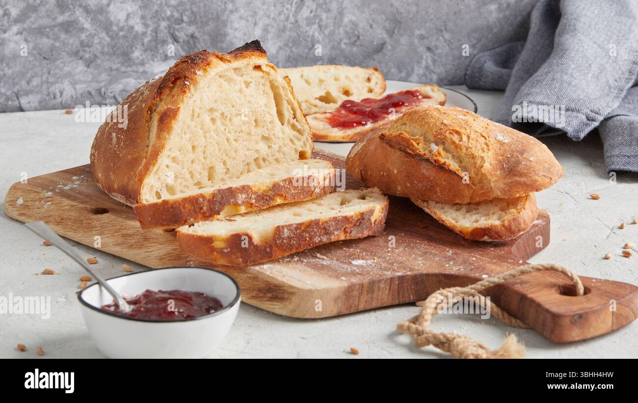 Bread on wooden board with jam – a rustic breakfast scene with sliced ...