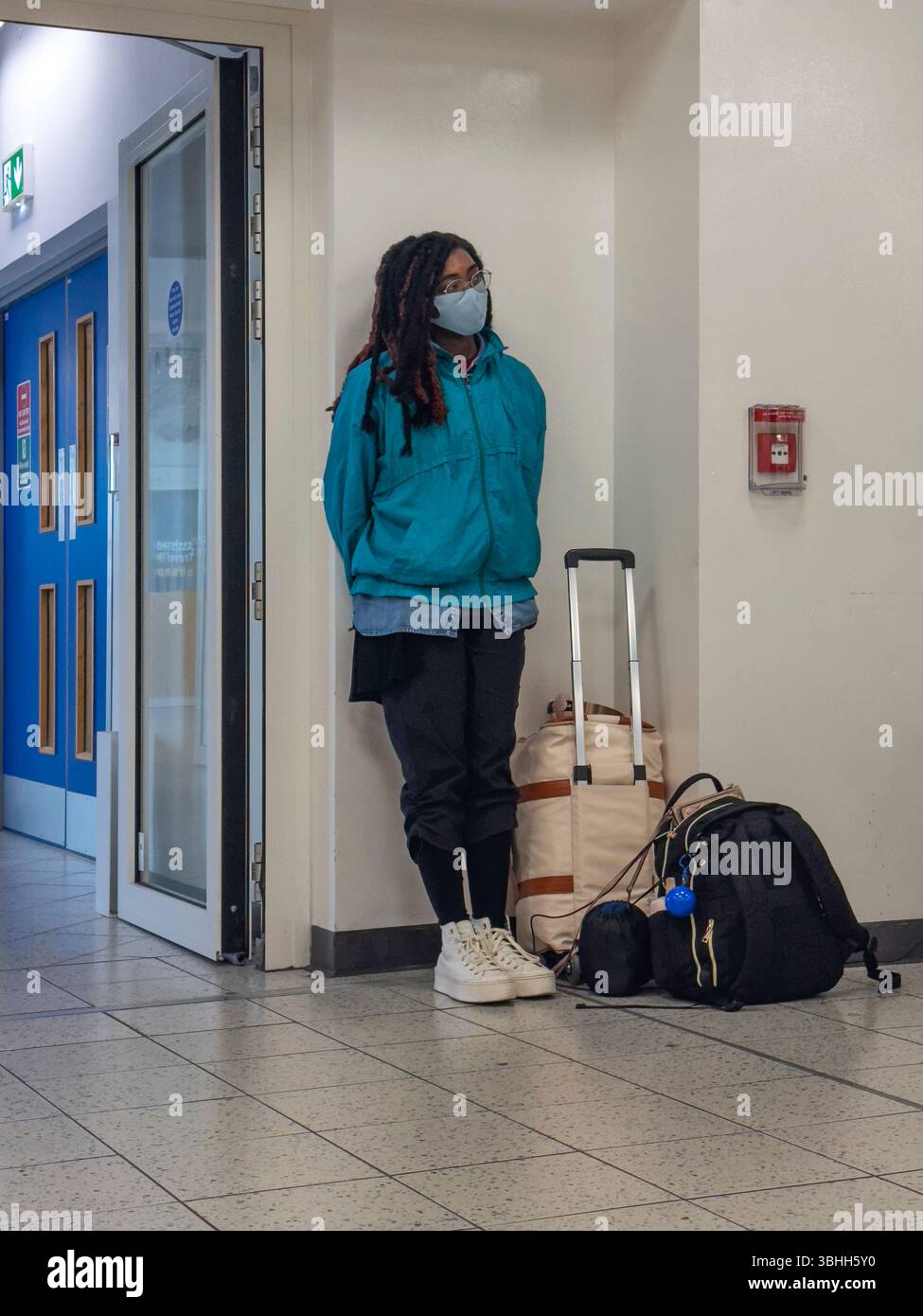 lone female air passenger wearing face mask standing in quiet isolated ...