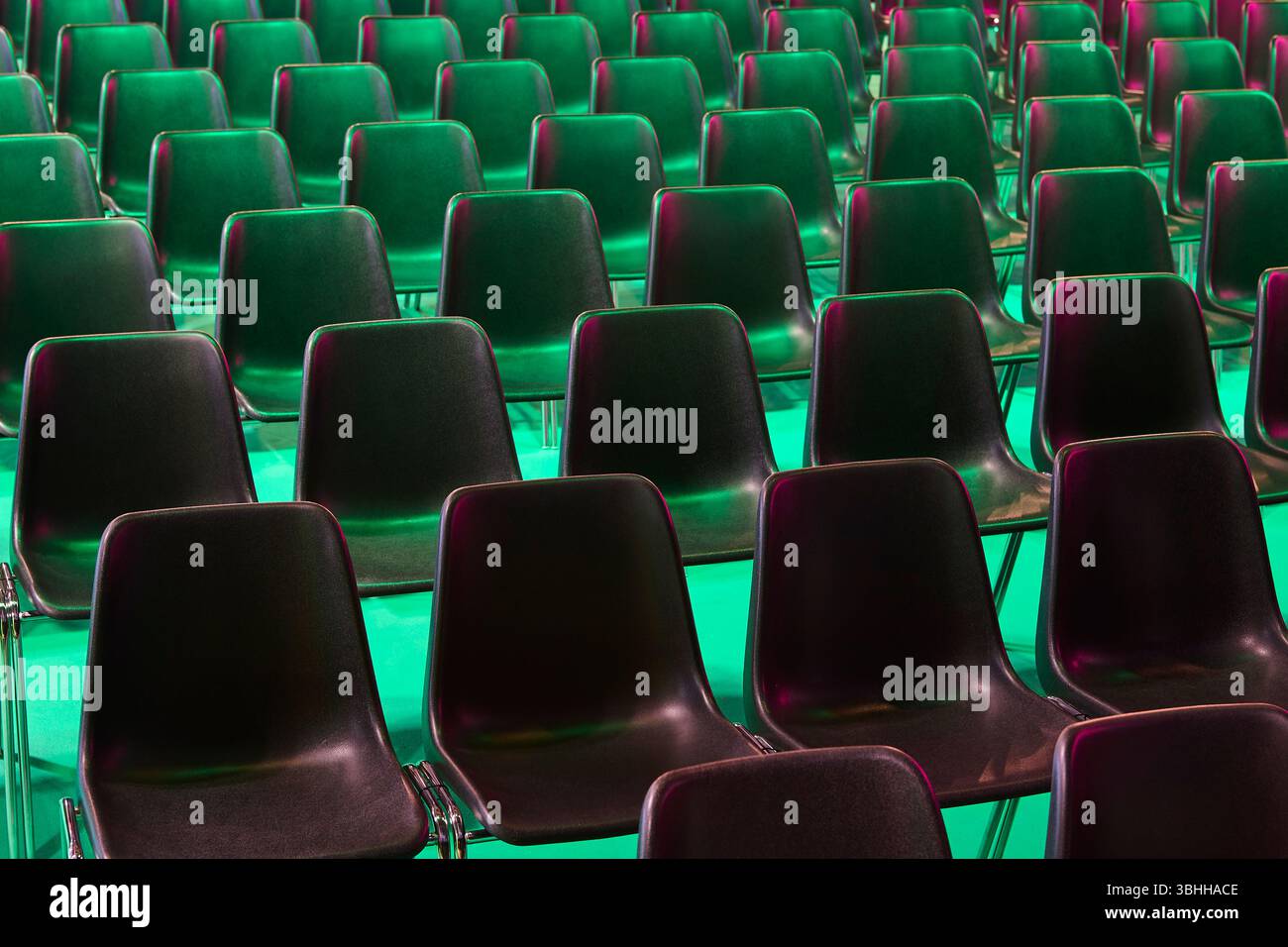Conference hall. Auditorium full of chairs illuminated by green light ...