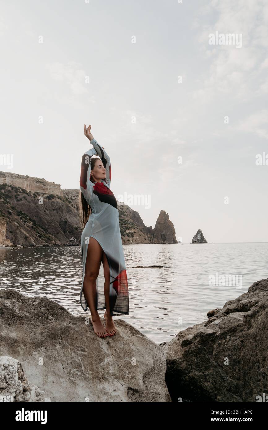 Woman Beach Pose Rocks - Woman in a long dress poses with her arms ...