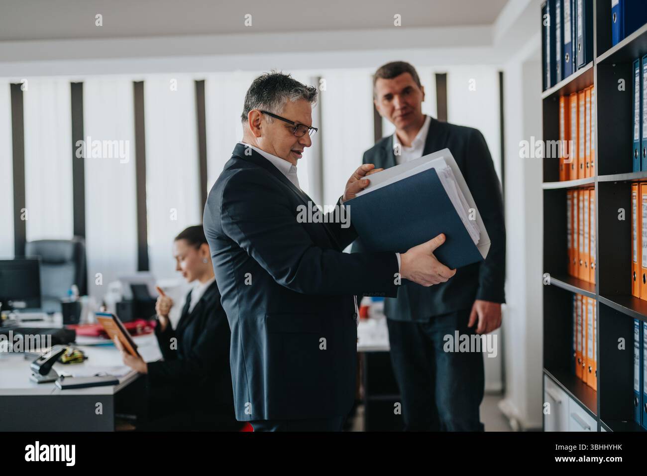 Business people collaborating and handling documents in an office ...