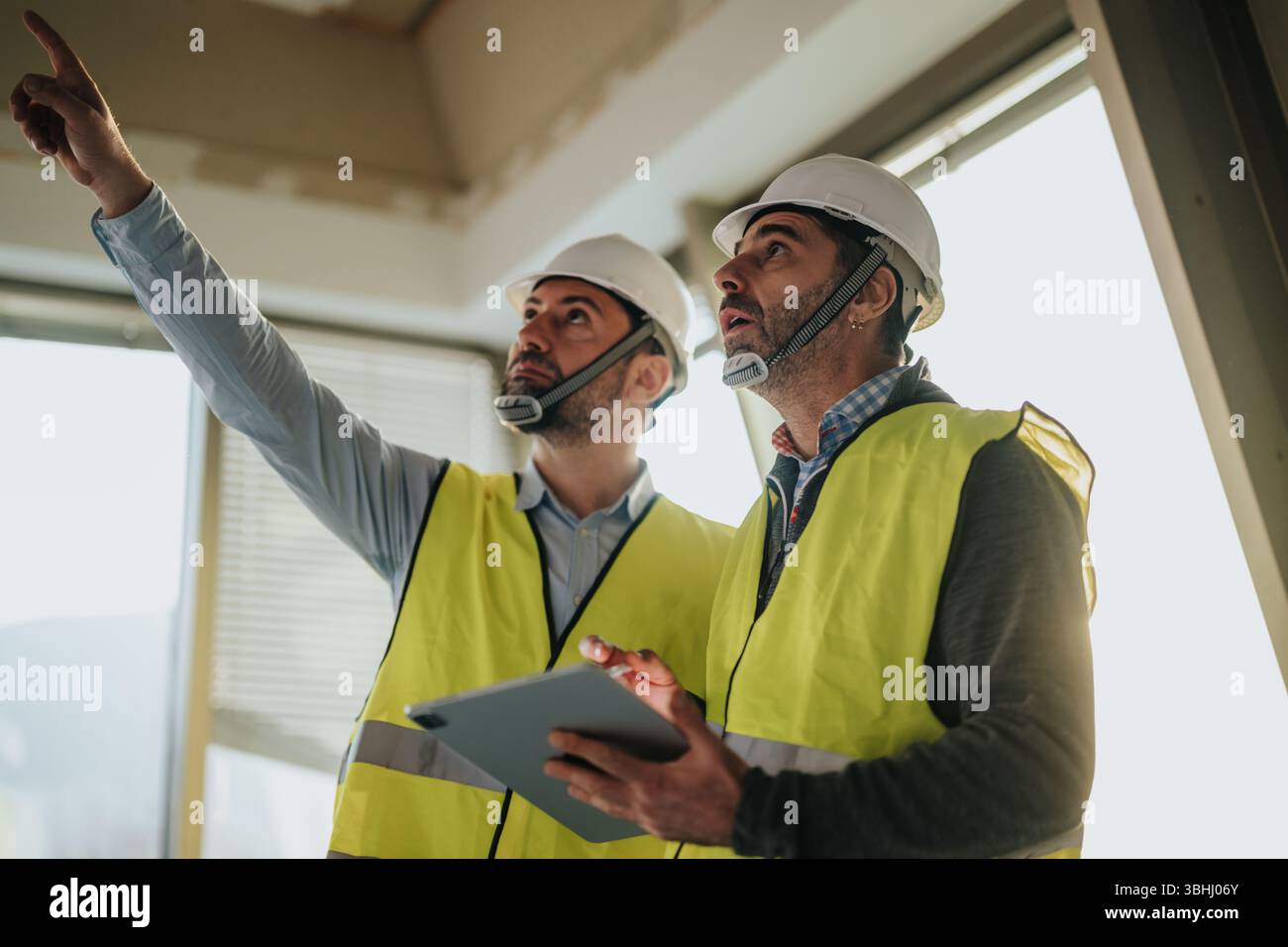 Two Construction Professionals Inspecting a Site with Safety Gear Stock ...