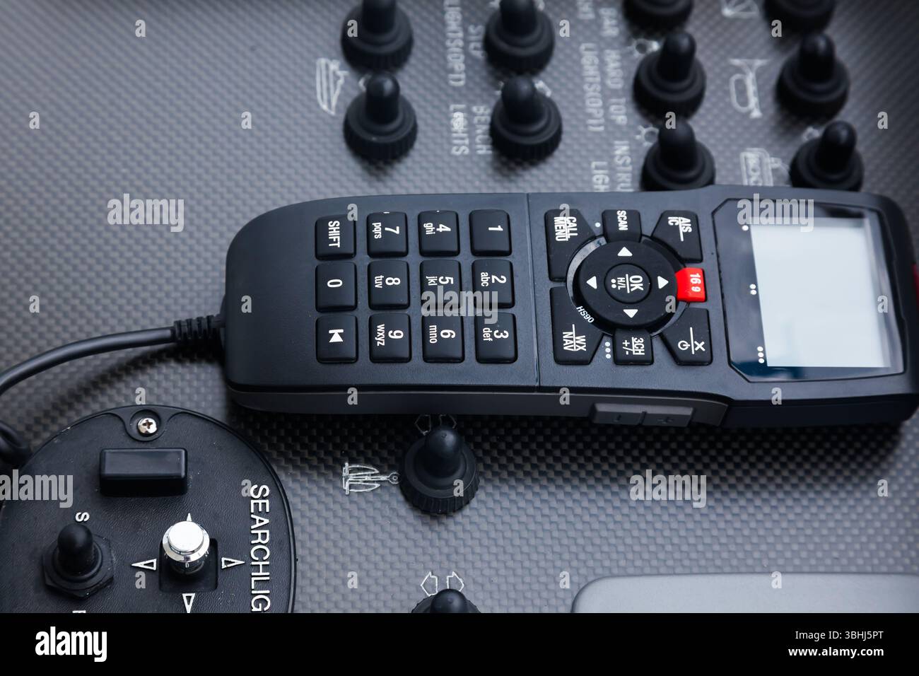 Black dashboard on a motor yacht with control buttons and a radio ...