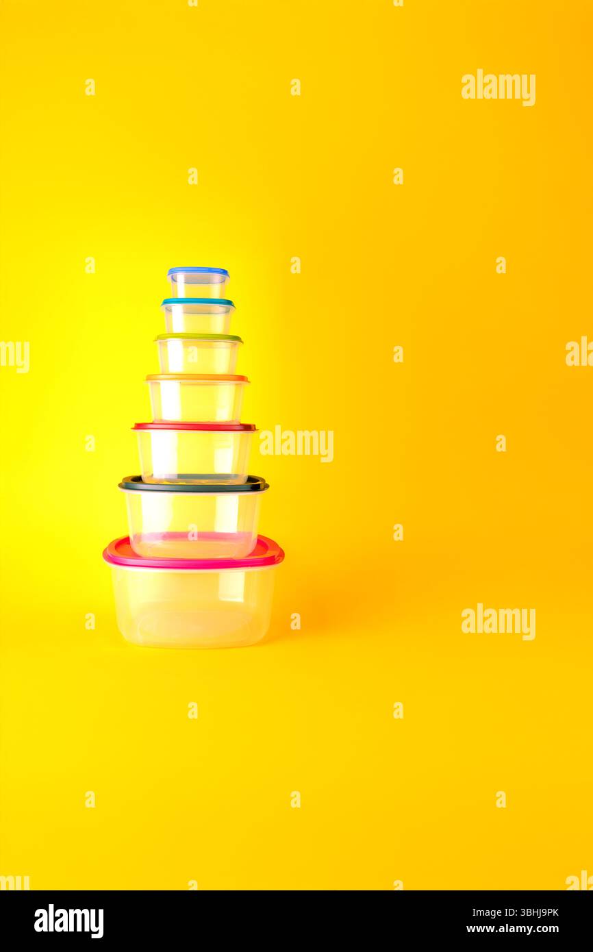 Stack of transparent plastic food containers with colorful lids ...