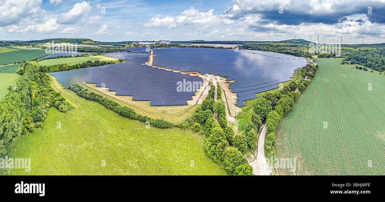 Drone picture of a massive solar farm surrounded by fields and forest ...