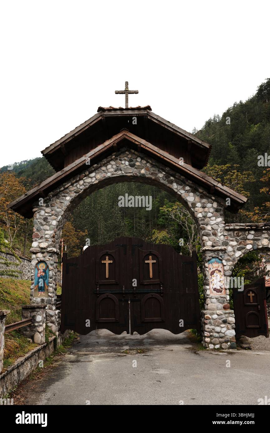 Stone gate with wooden doors and Orthodox cross at the entrance of Bele ...