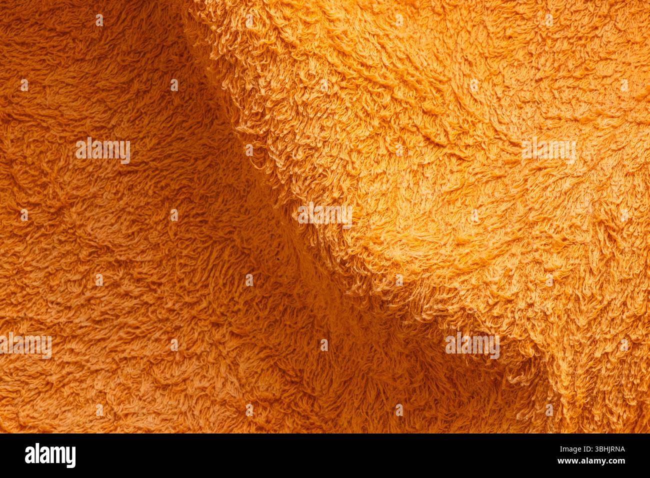 Orange terry towel close-up, soft fabric texture with loops, cozy ...