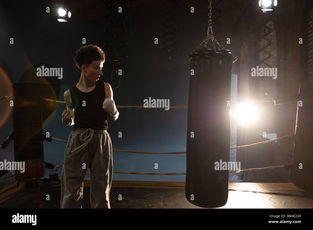 Woman boxer in ring with cinematic lighting, throwing powerful punch ...