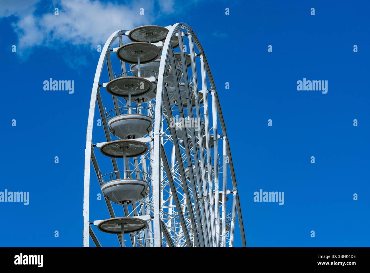 The towering structure of a Ferris wheel stands prominently against a ...