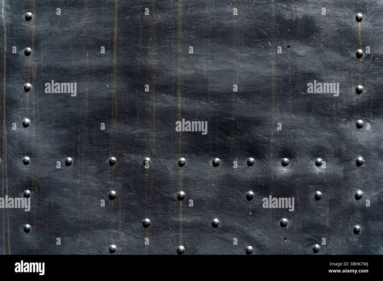 Rivets decorating a grunge black metal background, creating an ...